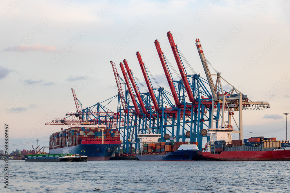 Huge container ship in the harbour of Hamburg, 400m long, sunset shot ...