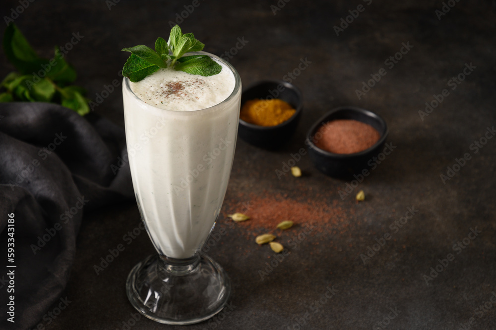 Indian Salty lassi with mint leaves and kala namak on black background ...