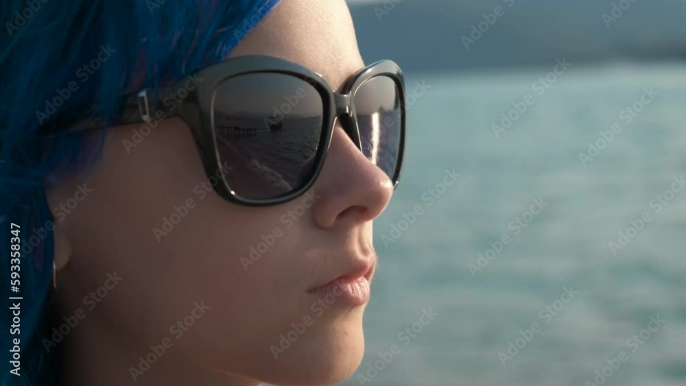 Reflection of the sun path in sunglasses. The face of a young girl with ...