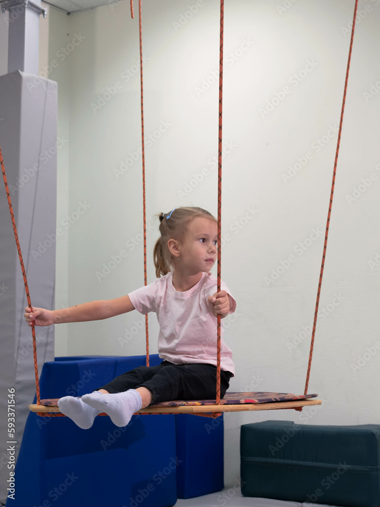 Foto de Child on swing during sensory integration session. Little girl ...