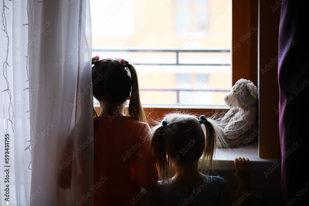 Beautiful little girl smiling and watching out the window. A child ...
