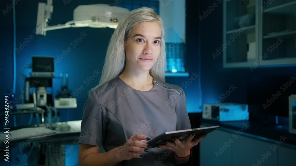 Portrait of blonde female Veterinarian, reviewing X-Ray Scan on tablet ...