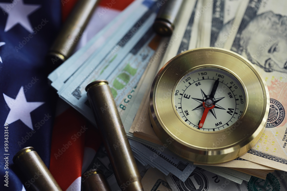 Money bill with golden Compass. Bullets and cartridge cases as a military concept. Close up US ...