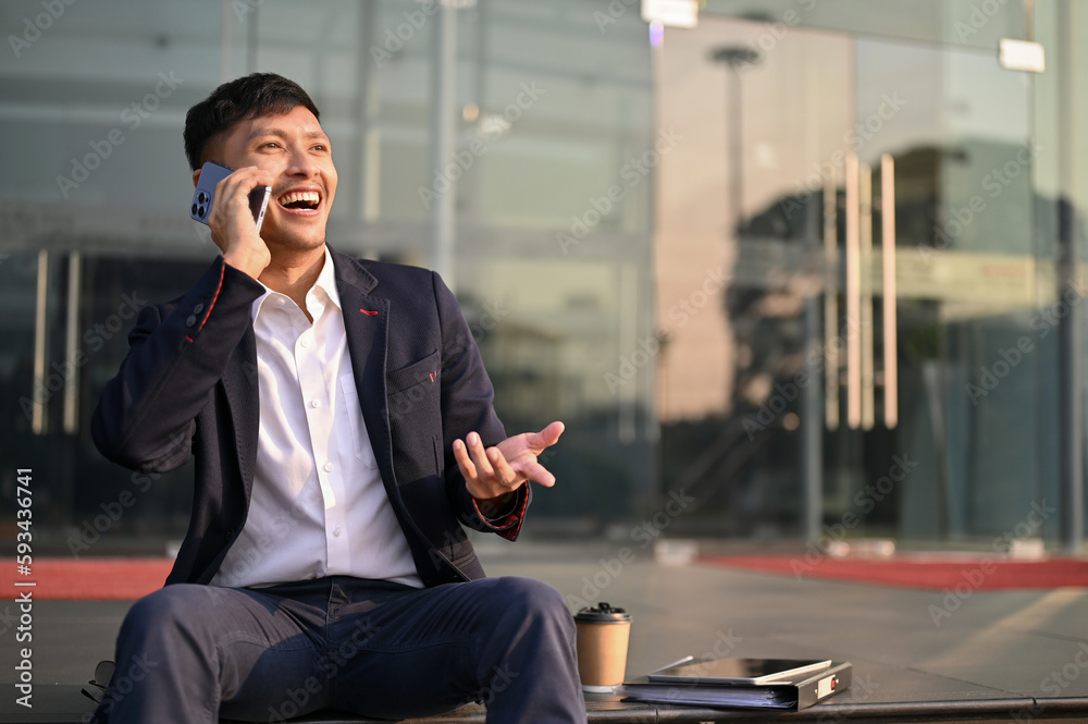 Cheerful Asian businessman laughed over the phone, on the phone while ...