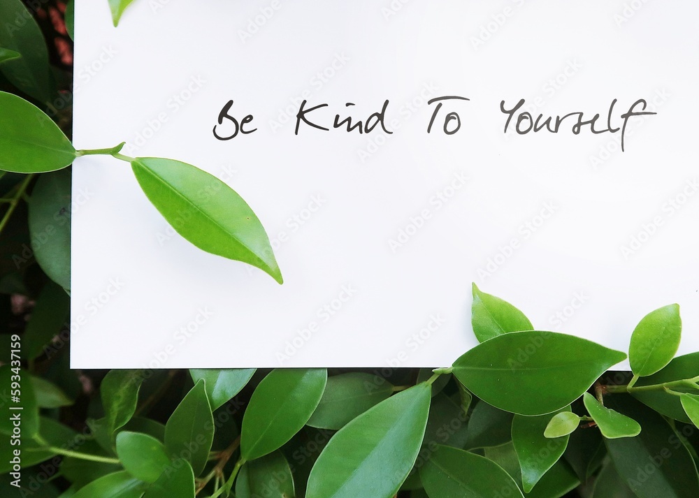 Handwritten paper on green plant background BE KIND TO YOURSELF ... Handwritten paper on green plant background BE KIND TO YOURSELF ...
