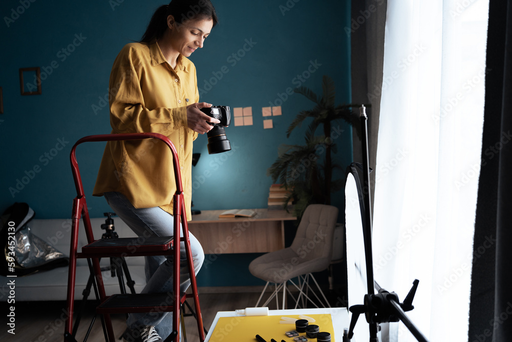 Female photographer setting up camera in home studio. Modern blogger ...