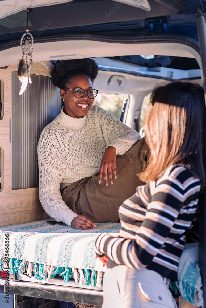 african woman laughing in a conversation with friend and enjoying van ...