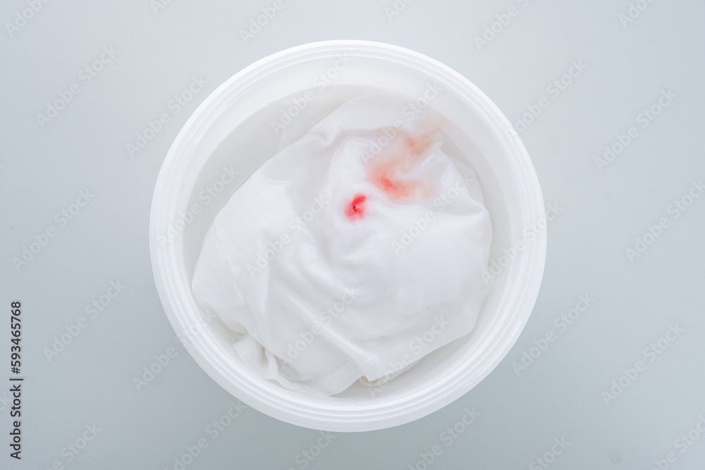 The blood stain on the clothes is soaked in cold water to remove any ...