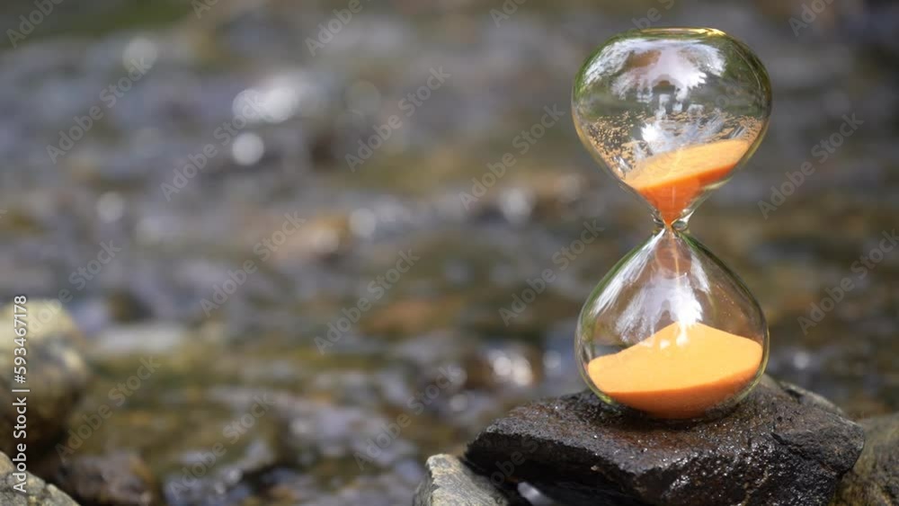 Stockvideon Time flows away like the water in the river. An hourglass ...