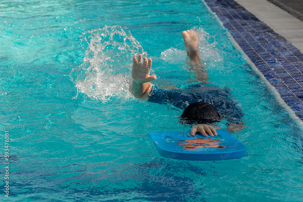 Asian young boy who a swimmer wearing dark blue suit dived in water ...