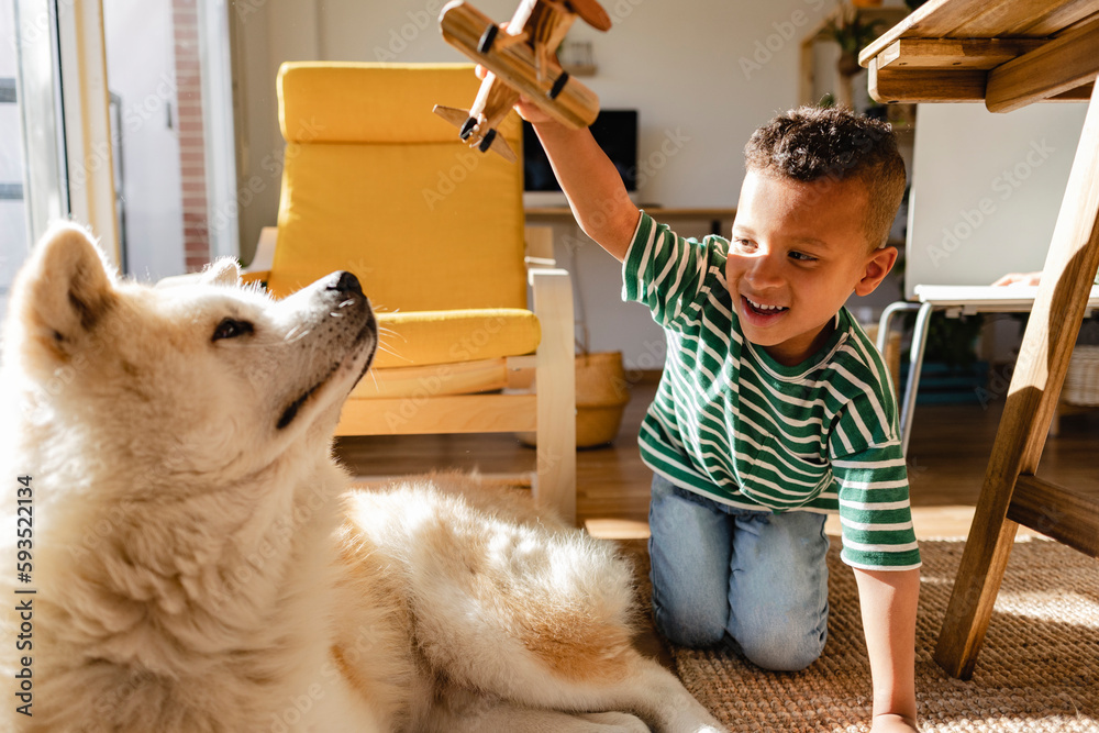Cute boy playing with dog at home Stock Photo | Adobe Stock
