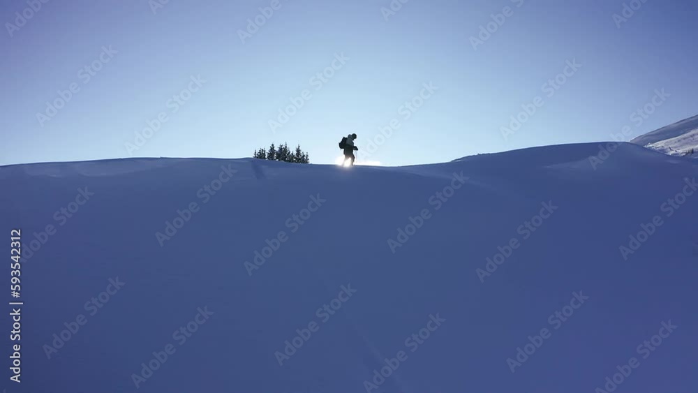 Aerial cinematic motion to the right featuring snowboarder split board ...