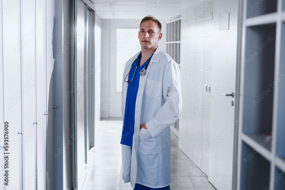Portrait of a man in a blue surgical suit and a white coat in a ...