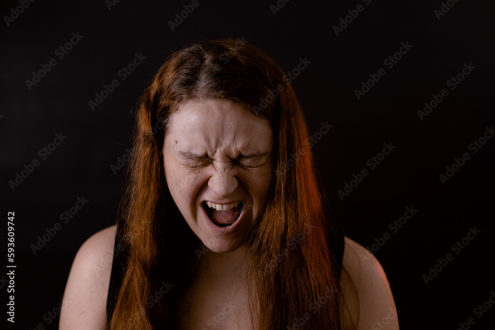 Young woman shout and scream loud with open mouth screwing up eyes ...