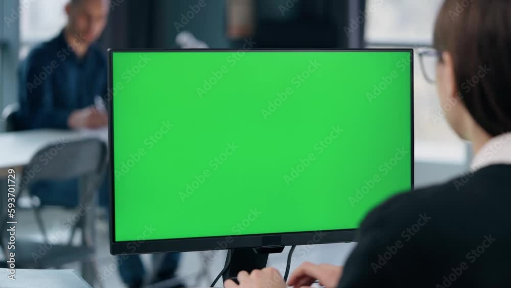 Young Girl Working At Computer With Green Mock Up Screen in Office ...