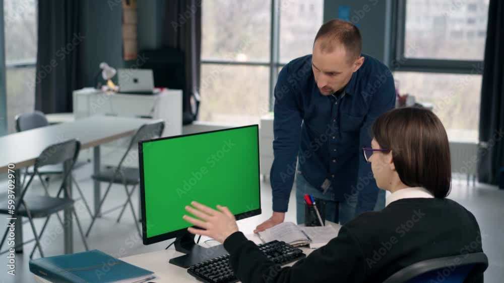 Young Woman Discusses Work Projects with a Male Colleague by Showing ...