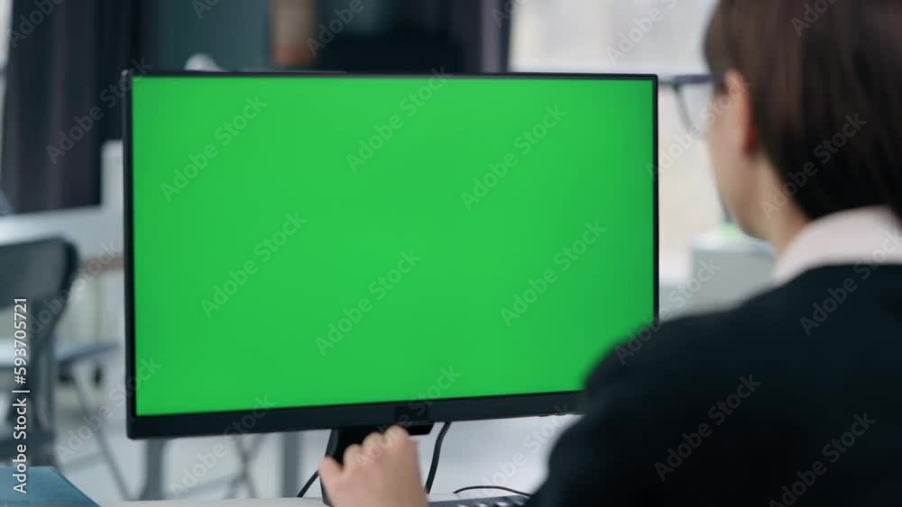 Young Girl Working At Computer With Green Mock Up Screen in Office ...