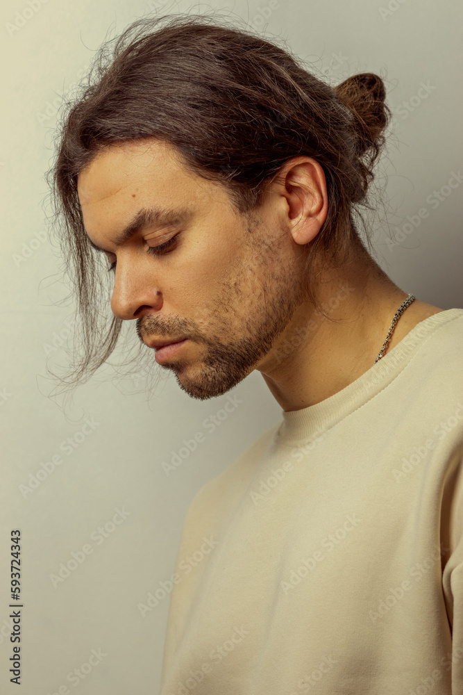 the man tilted his head down, his hair is disheveled and bangs hang ...