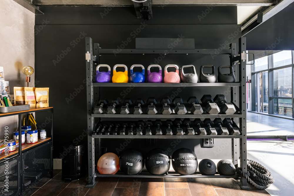 Gym rack with a set of dumbbells, kettlebells and exercise balls foto ...