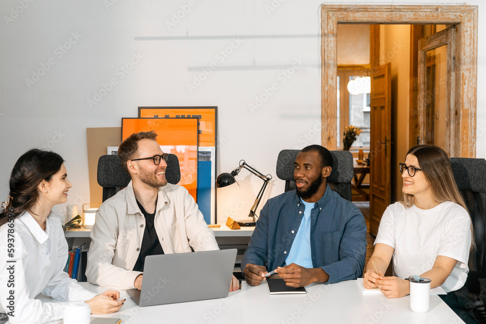 Colleagues in the office have a casual conversation during a meeting ...