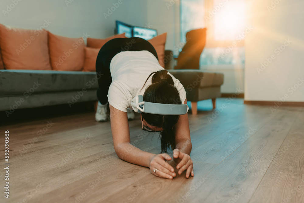 A woman stretching in her apartment during early morning after training ...