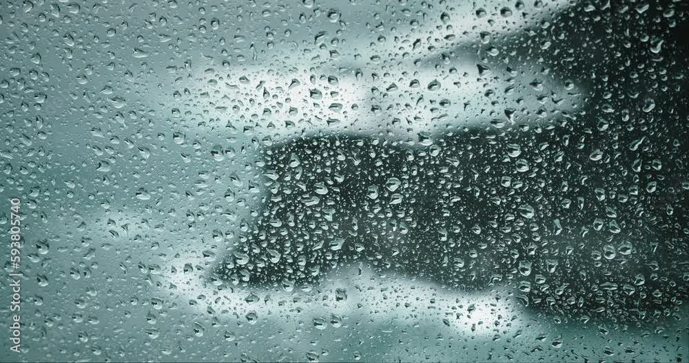 Raindrops on window pane view on severe sea waves foam and crash on ...