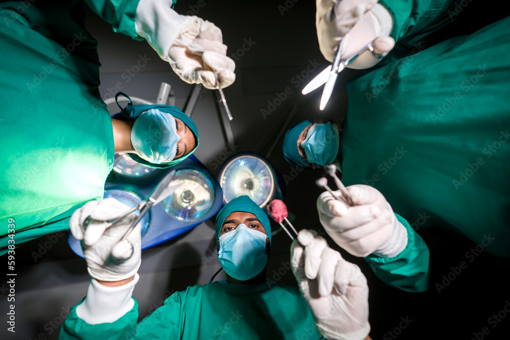 Group of surgeons and nurse in surgical green gown uniform performing ...