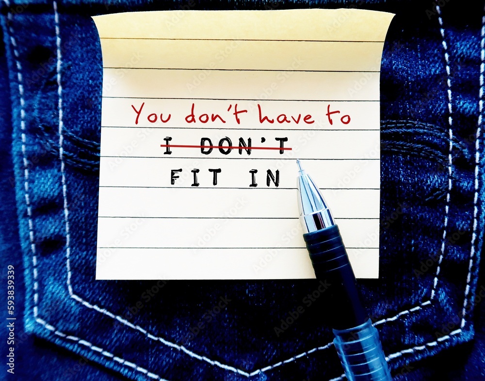 Pen on jean background with handwritten text on note paper I DONT FIT ...