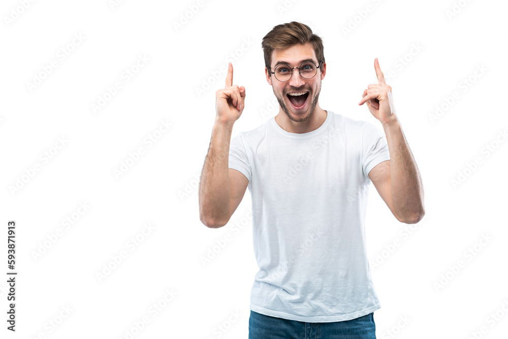 Portrait of a happy young man pointing fingers up at copy space ...