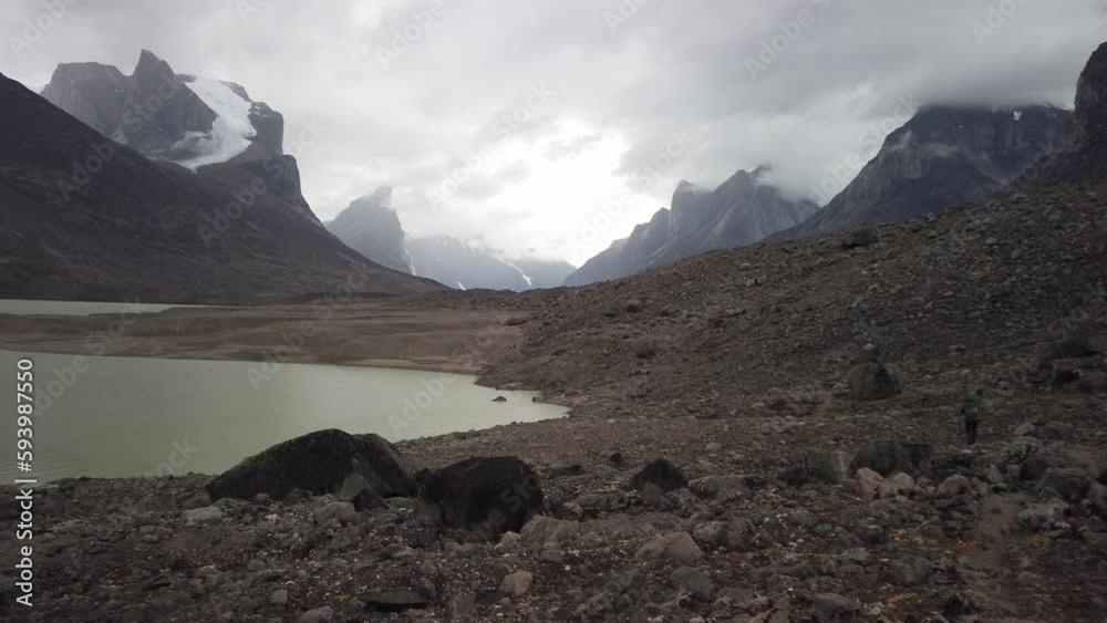 Male hiker with very big and heavy backpack walking around summit lake ...