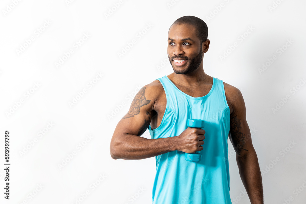 Muscular dark-skinned man poses on a white background in sportswear ...
