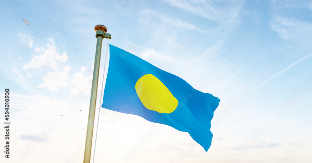 Flag of Palau waving in the wind, sky and sun background. Palau flag ...