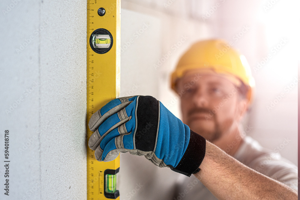 Hand holding a spirit level while measuring the verticality of the ...