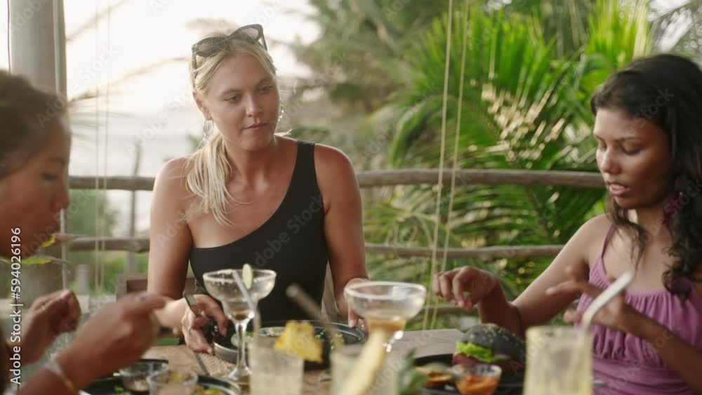 Diverse multiracial women friends having festive dinner and talking ...