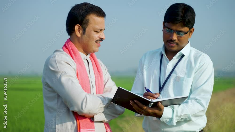 Officer writing by asking questions to Indian village farmer at ...