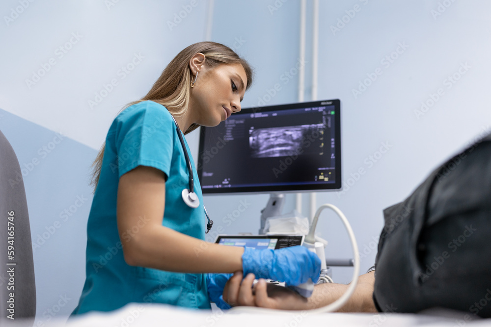 Female doctor doing ultrasound examination of patient's arm veins in ...
