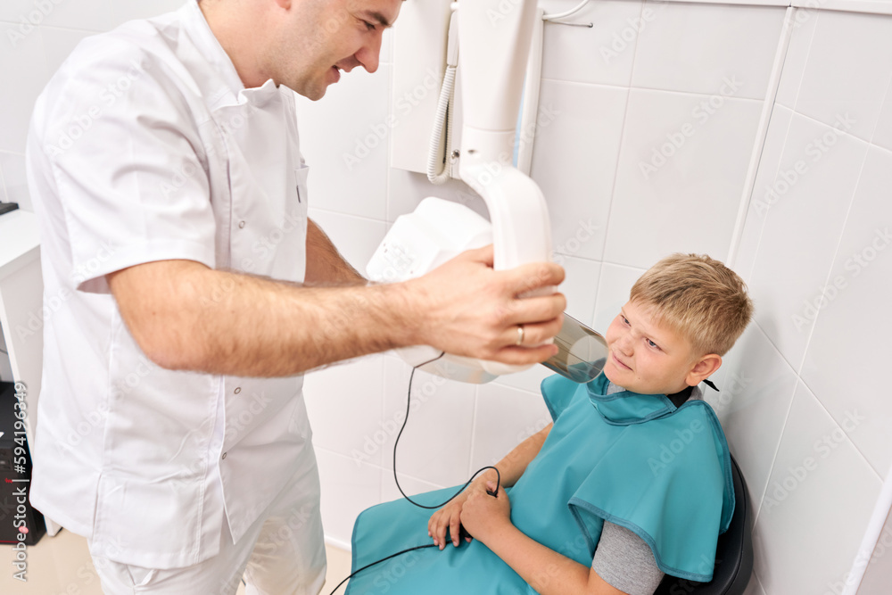 Radiographer taking teeth radiography to a boy using digital x-ray ...