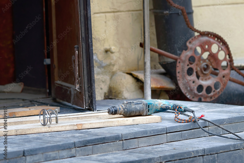 Rotary hammer with spiral mixing mortar nozzle on renovated porch. New ...