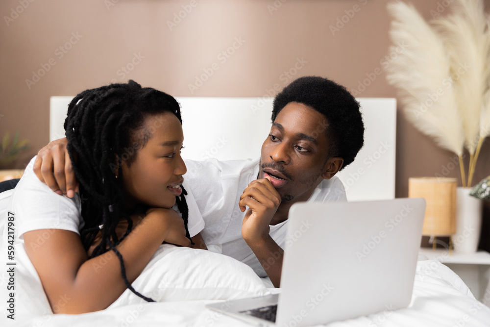 Dark skinned couple African American wife and husband lying on bed ...