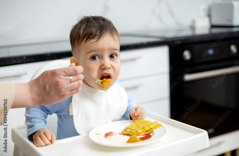 adorable baby boy kid eating peach pancake,mother hand feeding child ...