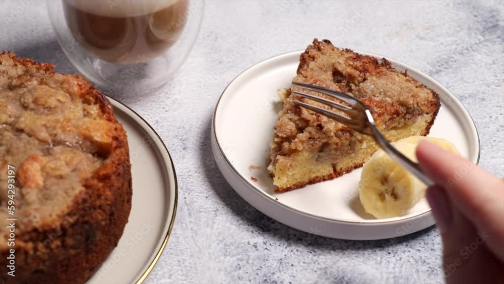 Pie Cuca de Banana on the table. The girl breaks a piece of cake with a ...