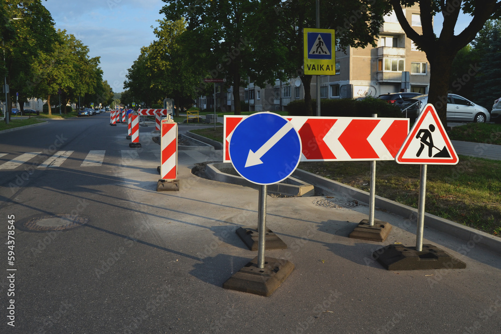 Road signs and barriers distinguish the working area for road works and ...