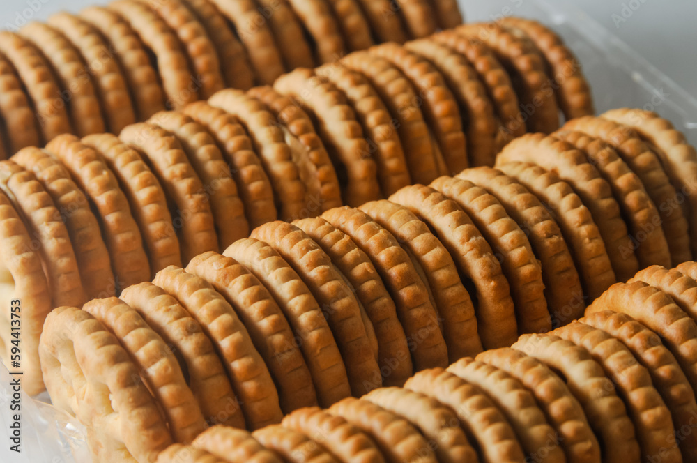 Several round biscuits with peanut butter arranged in a tight row in a ...
