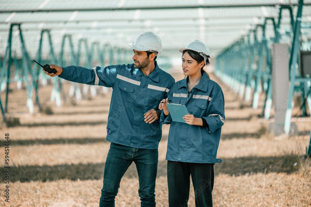 Solar design engineers visually inspect photovoltaic array installation ...
