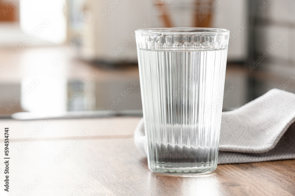 Glass of water and napkin on kitchen counter, closeup Stock Photo ...
