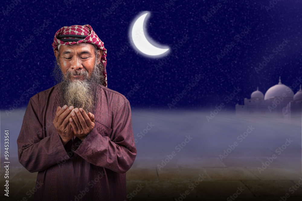 Muslim man with a beard wearing keffiyeh with agal in praying while ...