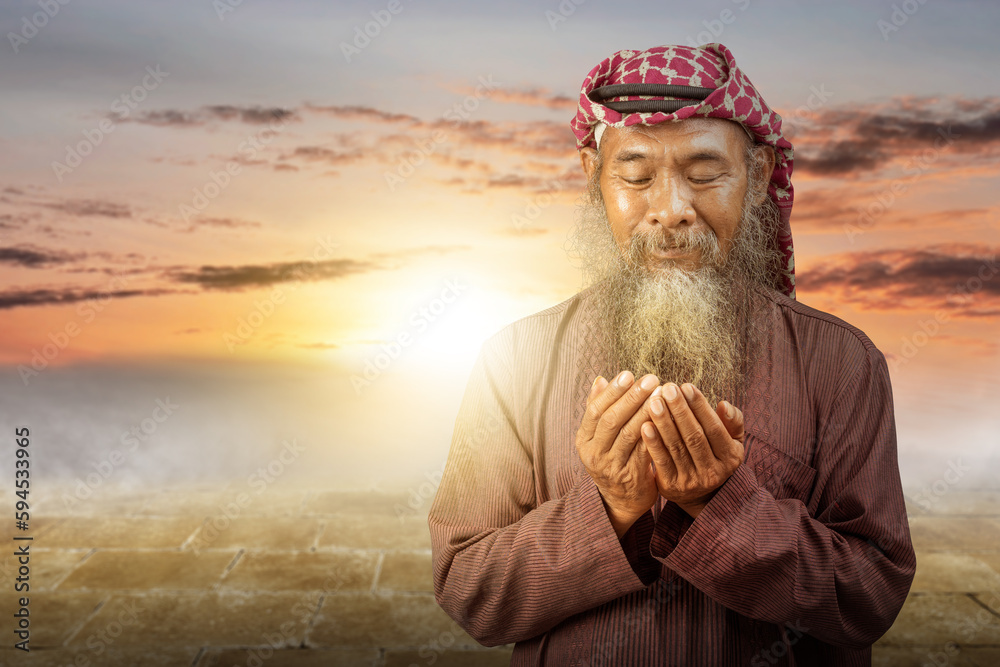 Muslim man with a beard wearing keffiyeh with agal in praying while ...