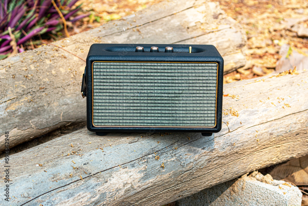 black portable wireless speaker on natural timber background, vintage ...