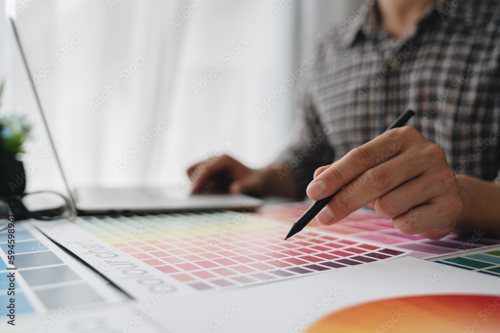 Engineer, graphic, architect looking at details and pointing at color ...