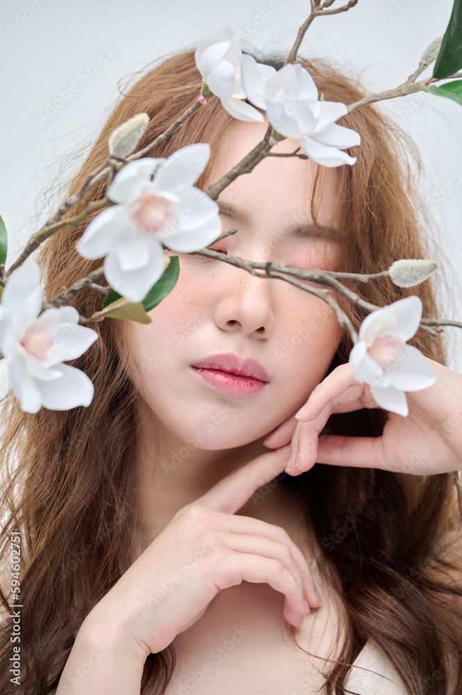 Beautiful Young Asian woman behind flower in beauty pose. Pretty girl ...